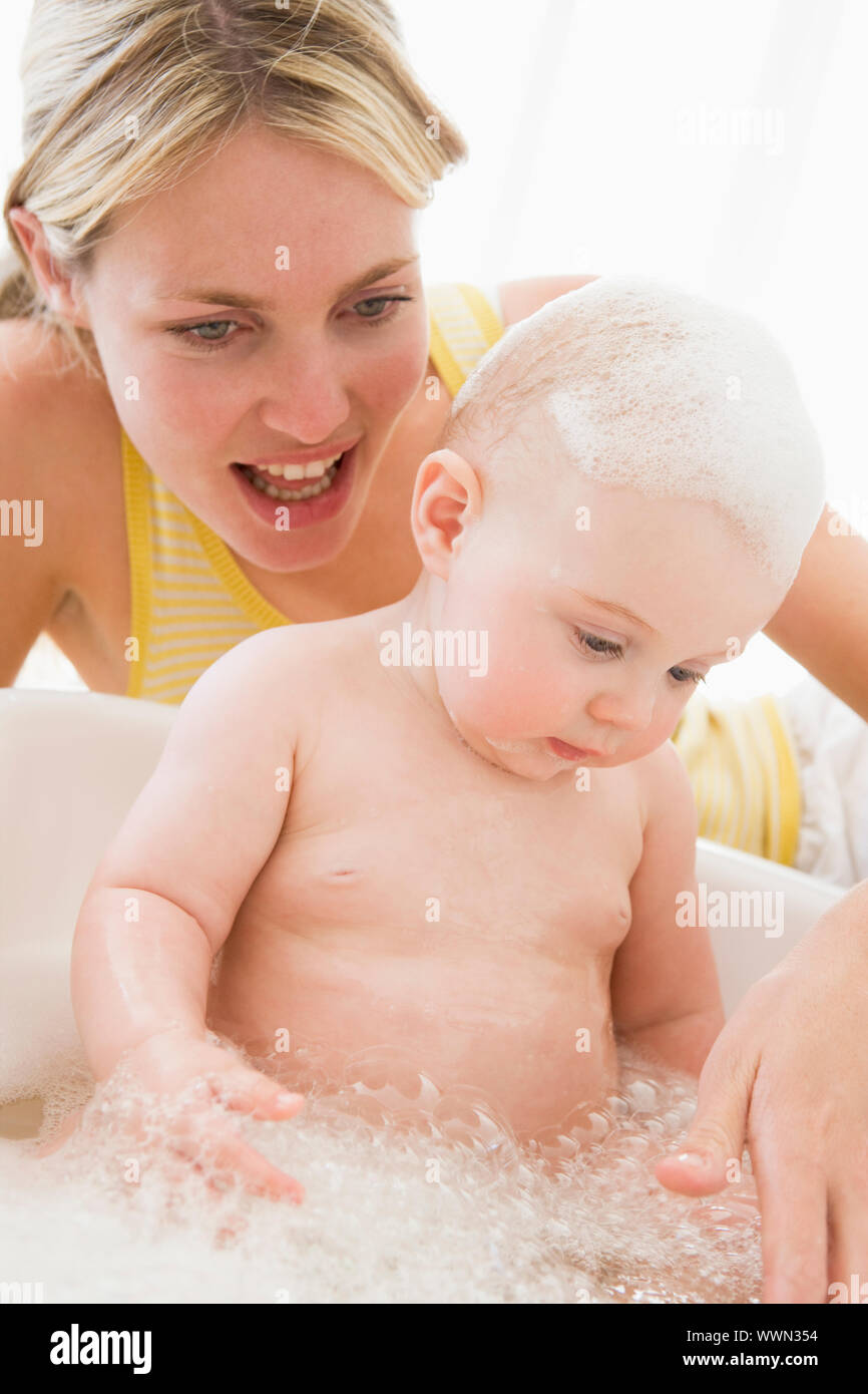 Woman giving baby bath hi-res stock photography and images - Alamy