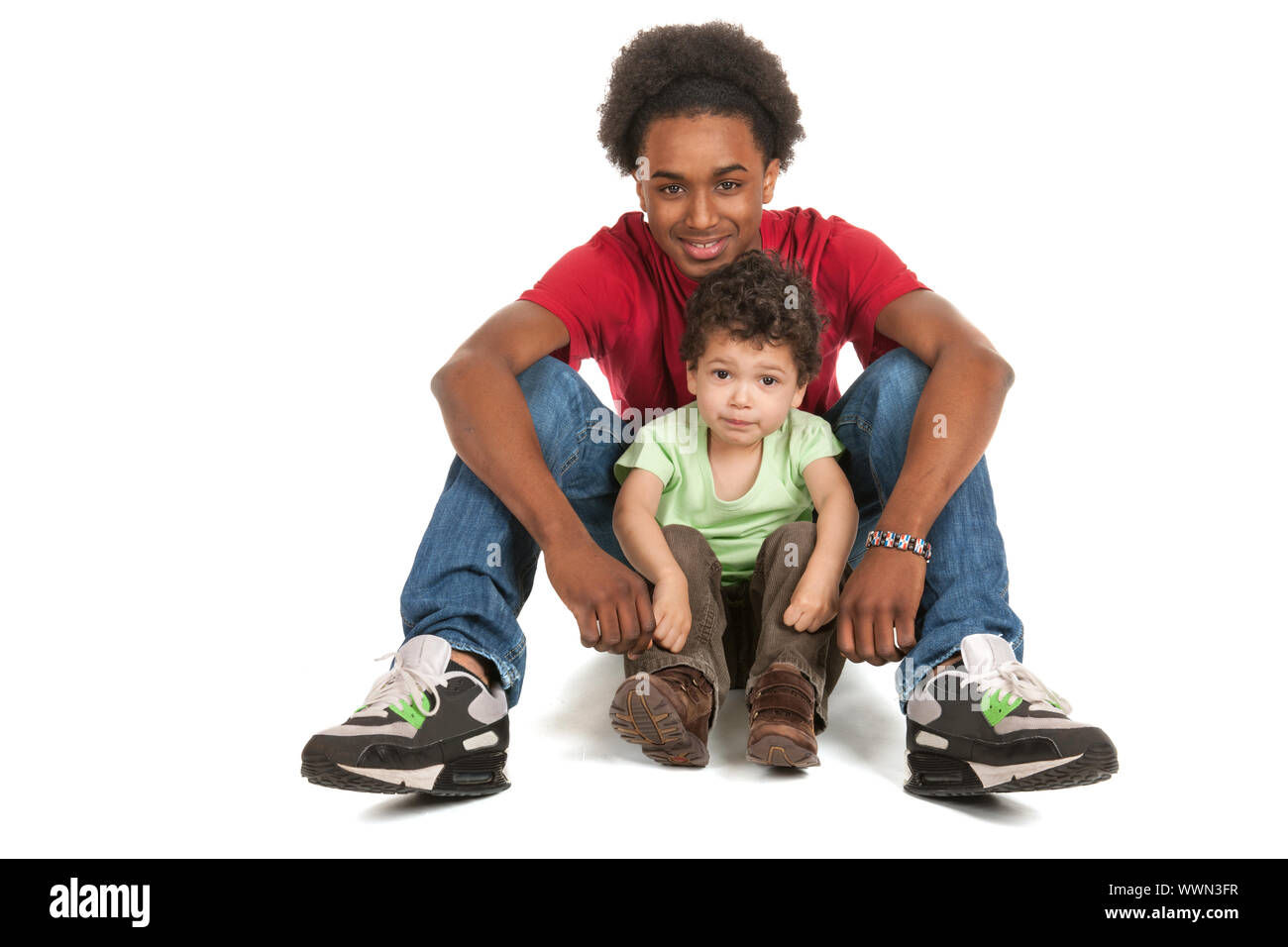 Two multi-cultural half brothers sitting in studio Stock Photo - Alamy