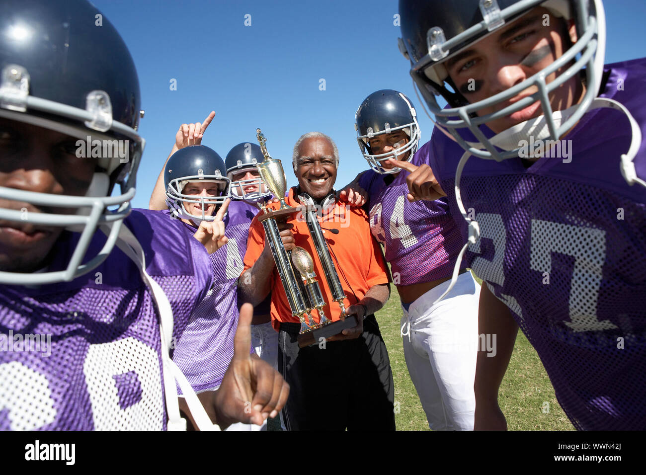 Happy Football Coach with Trophy and Players Stock Photo - Alamy