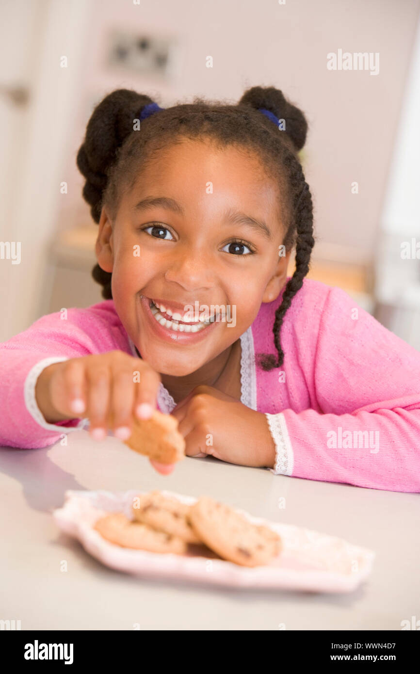 Girl eating cookies at home Stock Photo - Alamy
