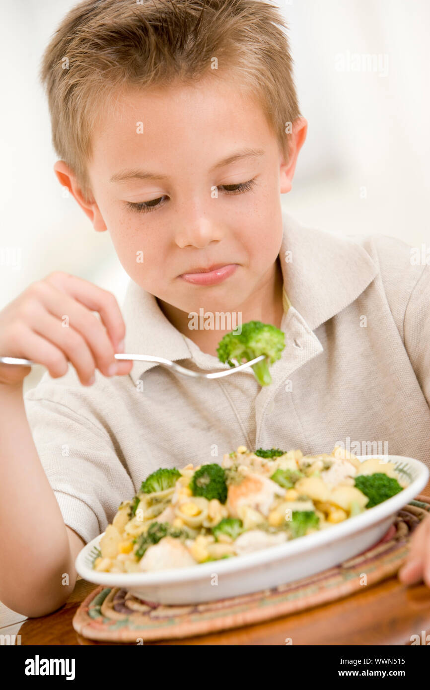 Young boy indoors eating food Stock Photo - Alamy