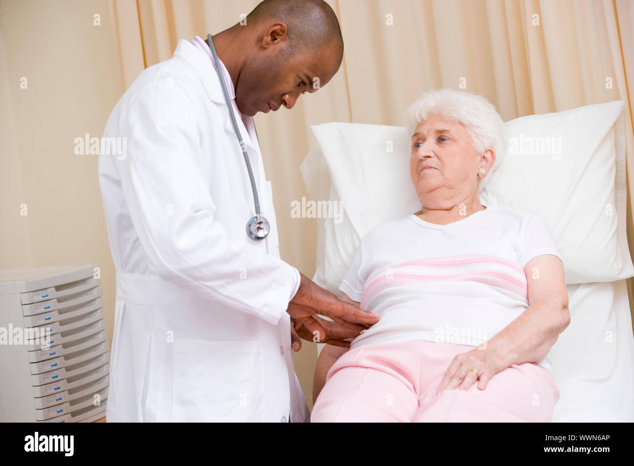Doctor giving checkup to woman in exam room Stock Photo - Alamy