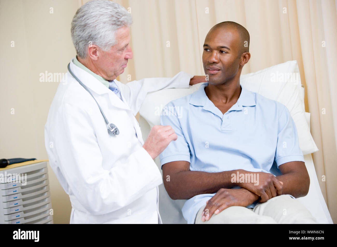 Doctor giving man checkup in exam room Stock Photo - Alamy