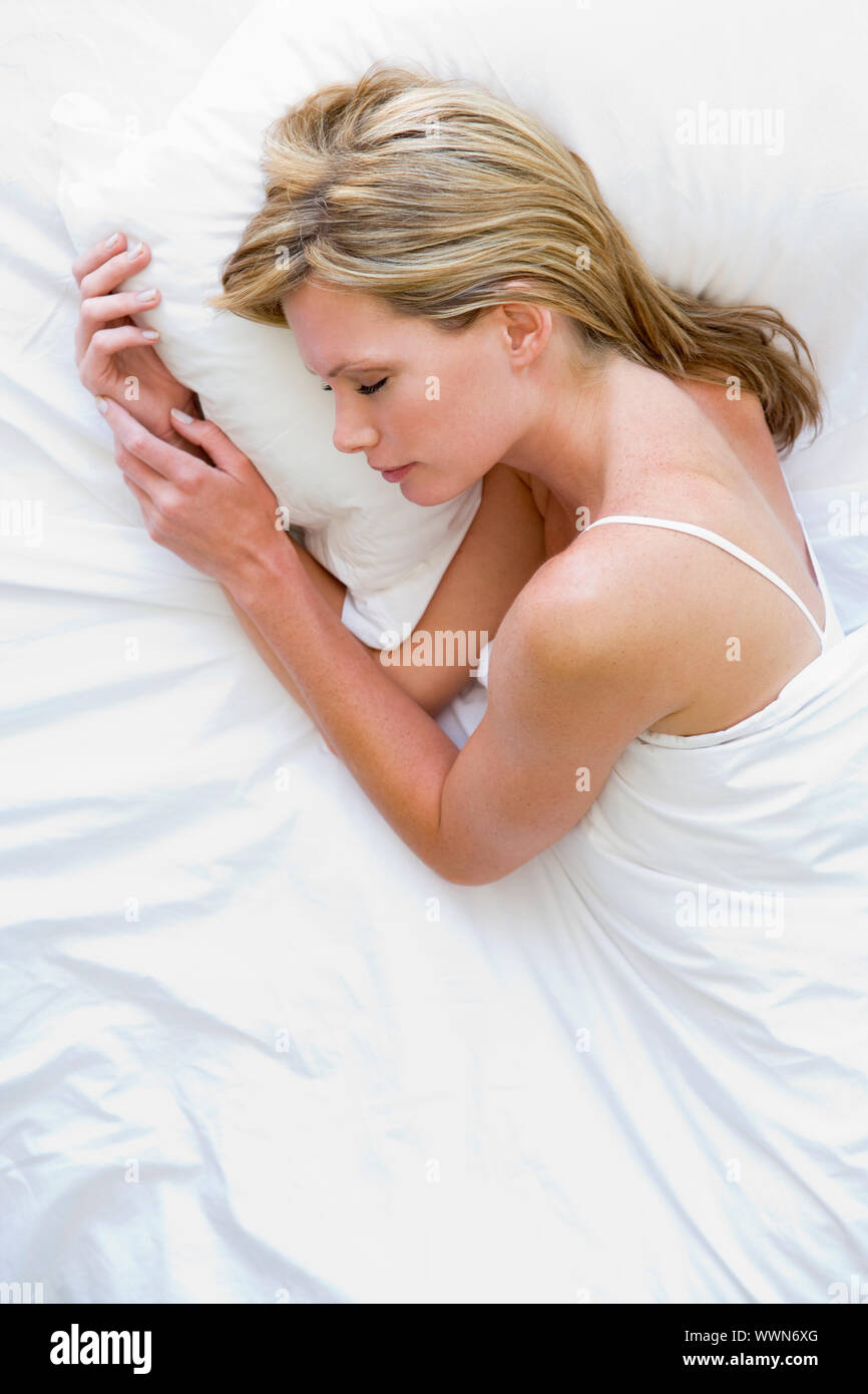 Woman lying in bed sleeping Stock Photo - Alamy