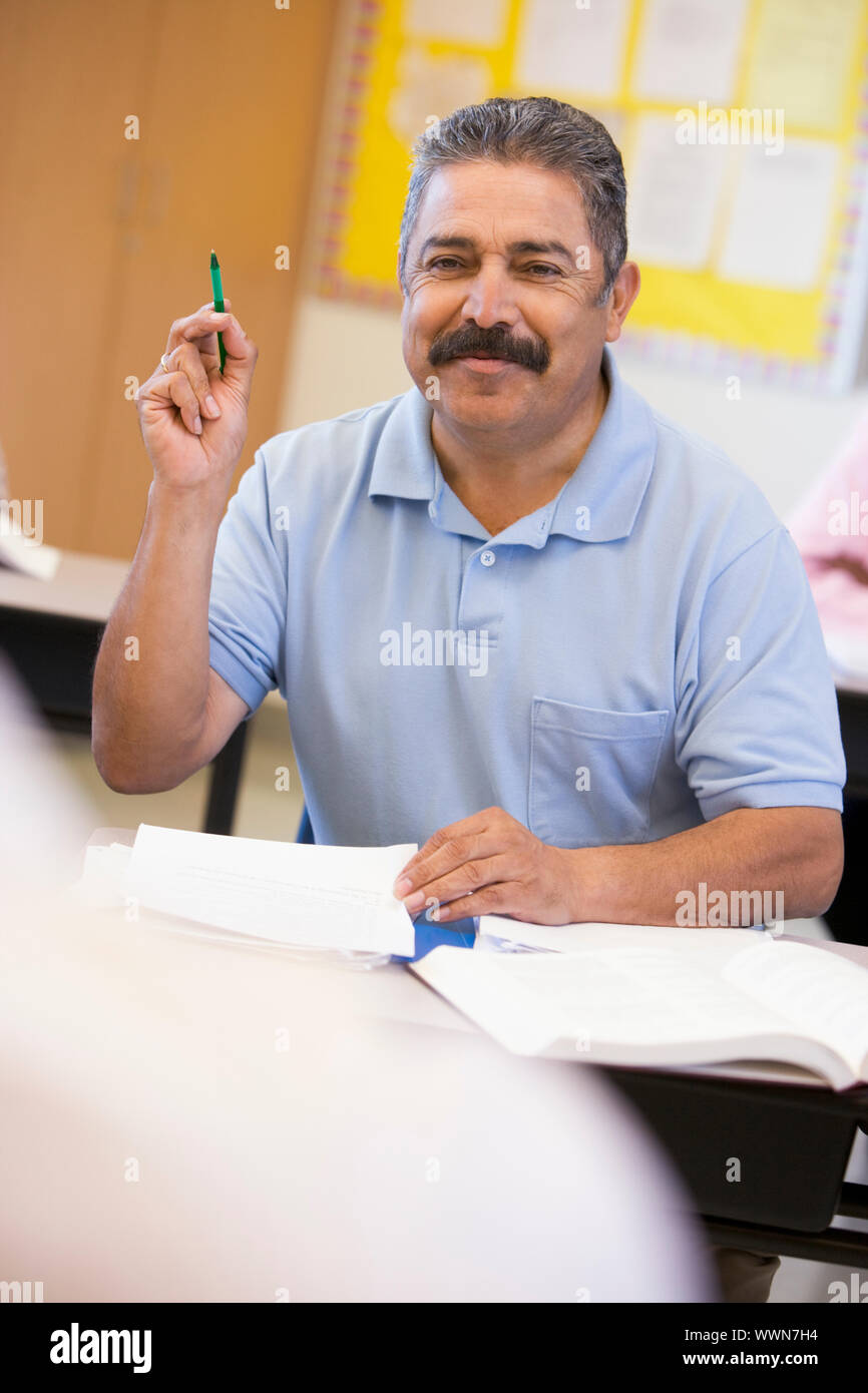 Mature male student raising hand in class Stock Photo - Alamy