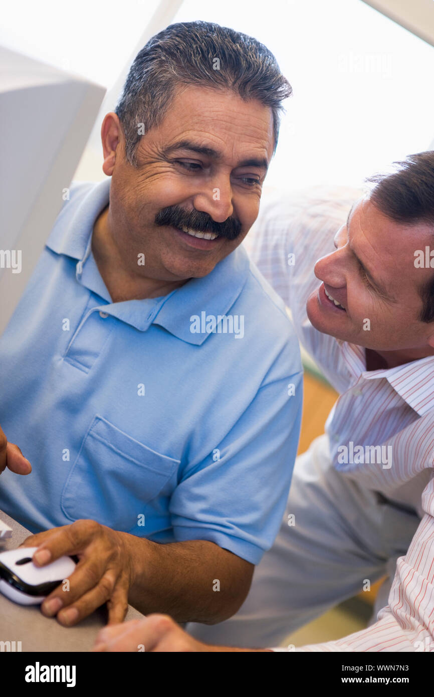 Mature male student learning computer skills Stock Photo - Alamy