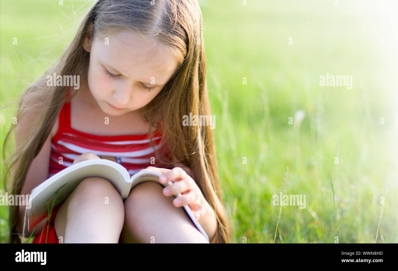girl with long hair, reading a book Stock Photo - Alamy