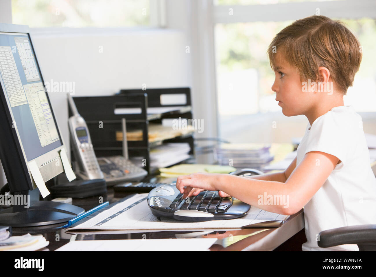 Young boy in home office with computer typing Stock Photo - Alamy
