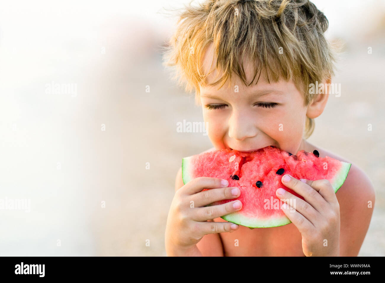 boy taking a bite of watermelon Stock Photo - Alamy