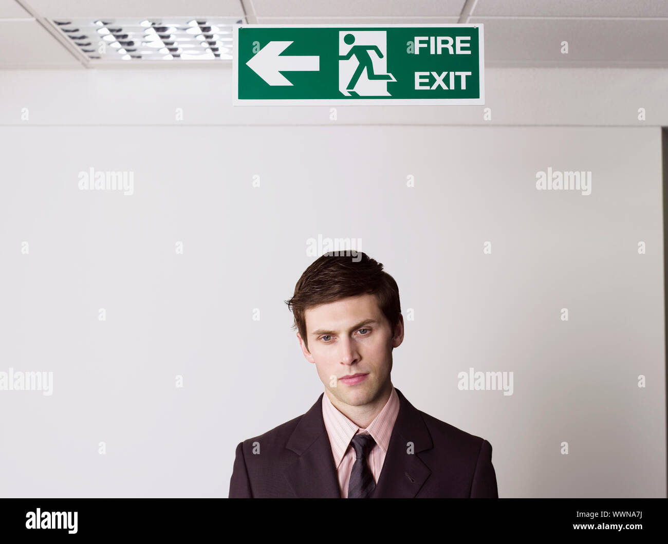 Businessman Standing Under Exit Sign Stock Photo - Alamy