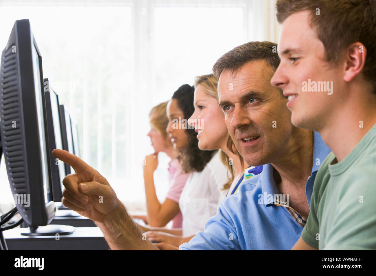 Teacher assisting college student in a computer lab Stock Photo - Alamy