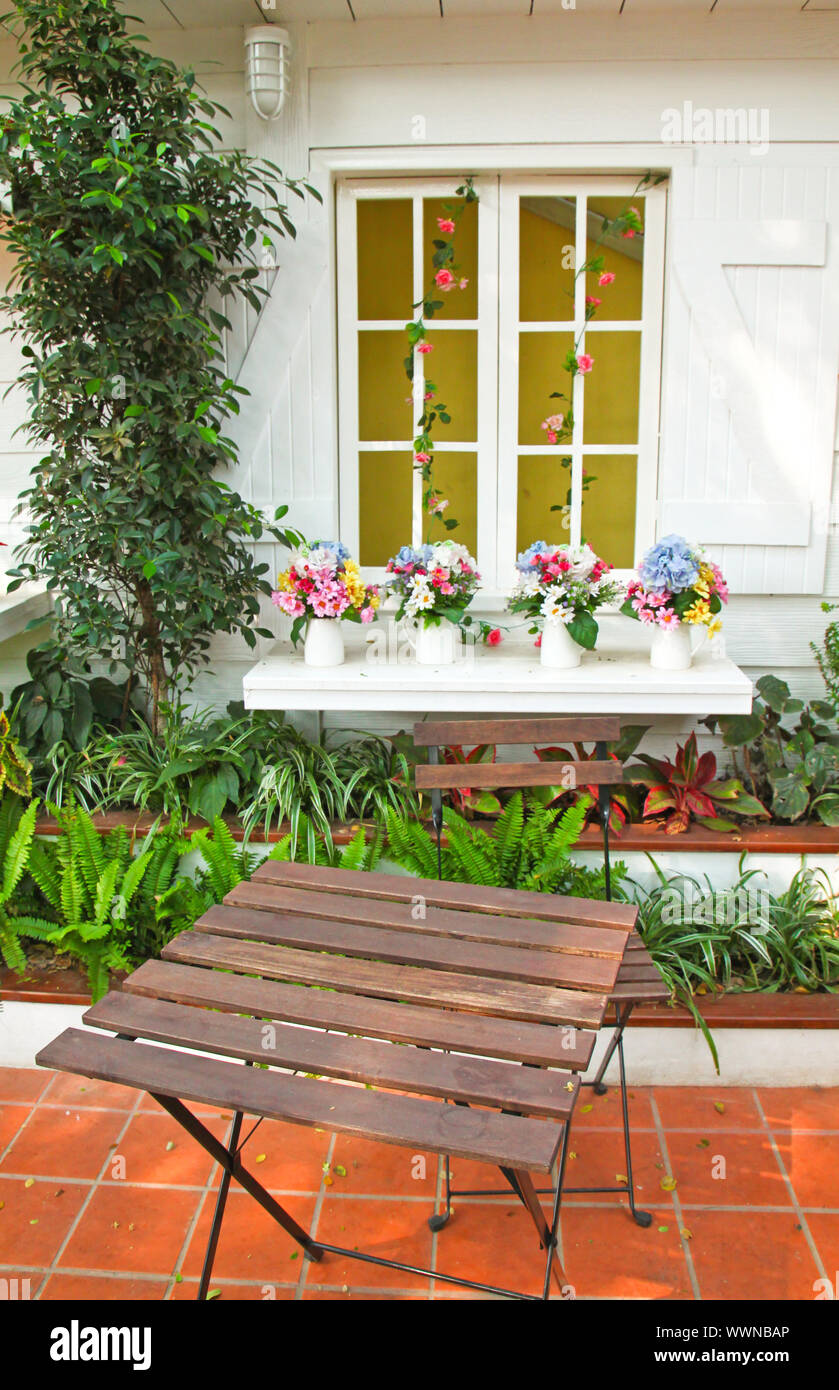 Decorated flowers on window with table and chair in garden Stock Photo ...