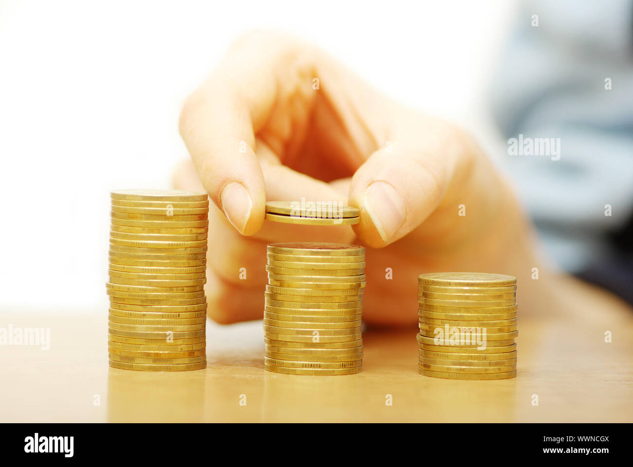 Hand put coin to money staircase isolated on white background Stock ...