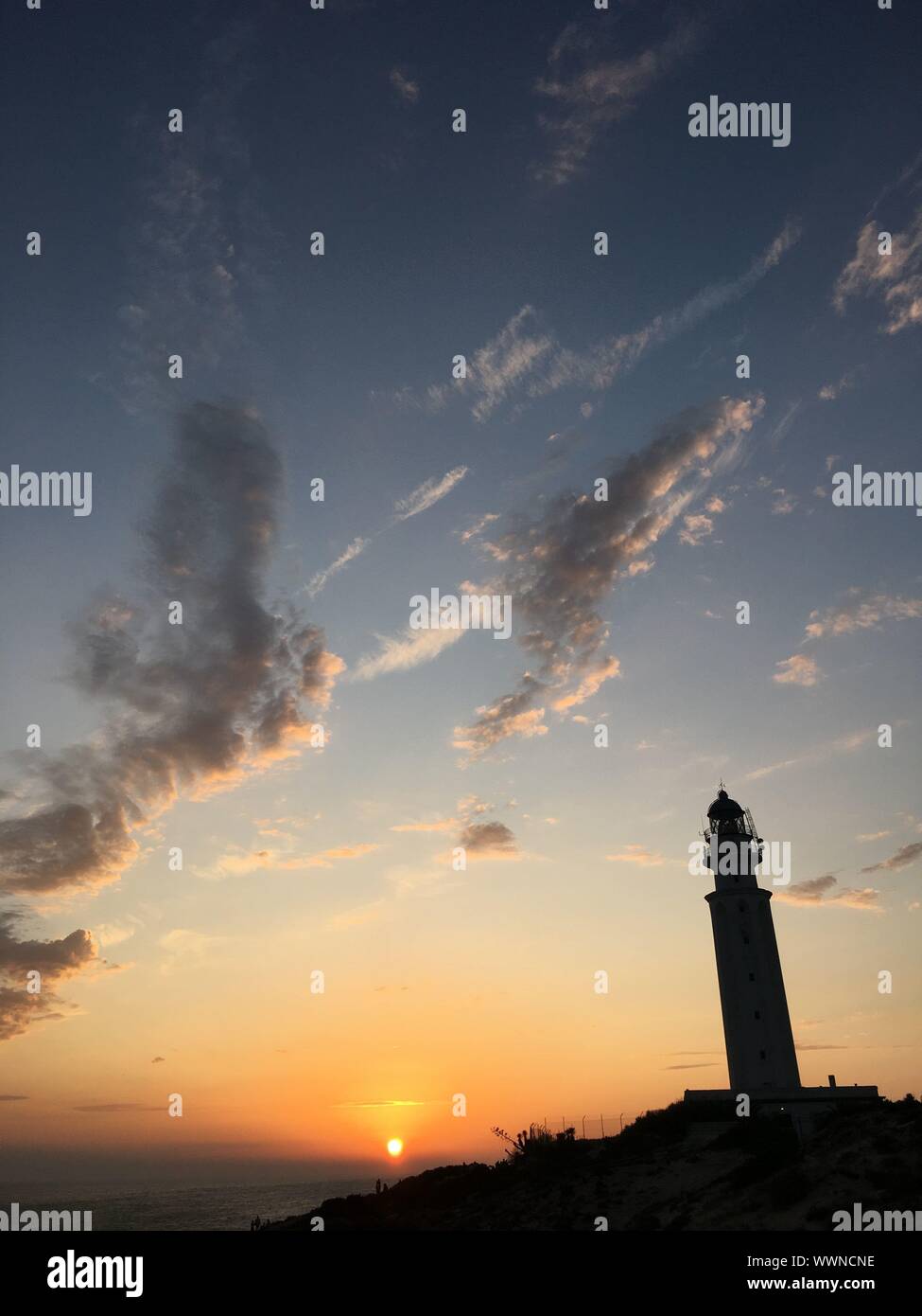Trafalgar lighthouse on the coast of Cadiz at sunset Stock Photo - Alamy