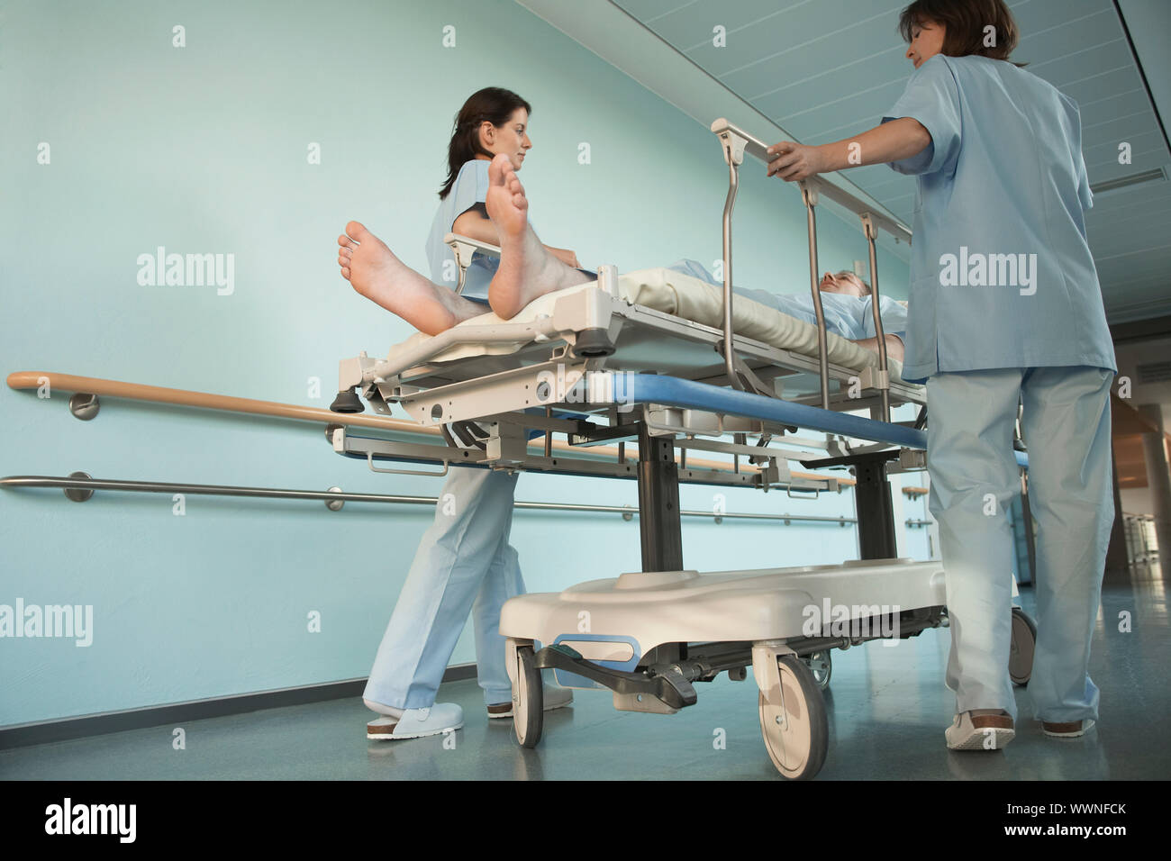 Nurses Moving Patient in Corridor Stock Photo - Alamy