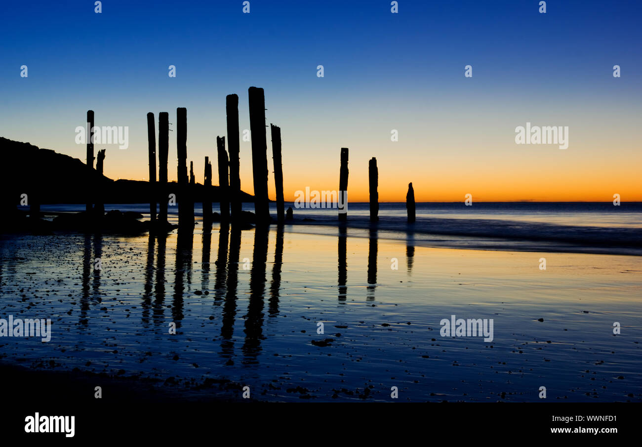 Old Jetty pilons at sunset Stock Photo - Alamy
