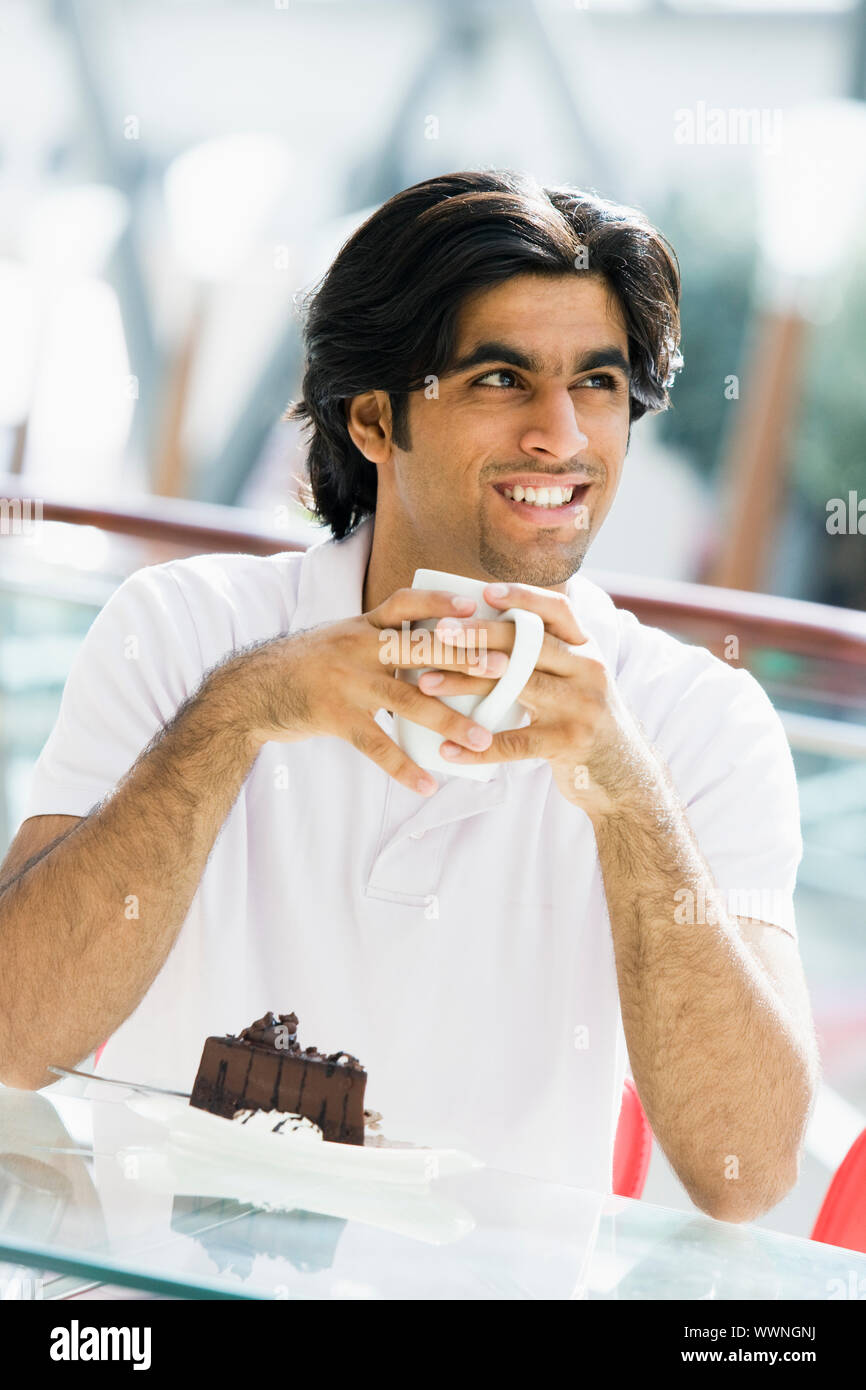 Man at restaurant eating dessert and smiling Stock Photo - Alamy