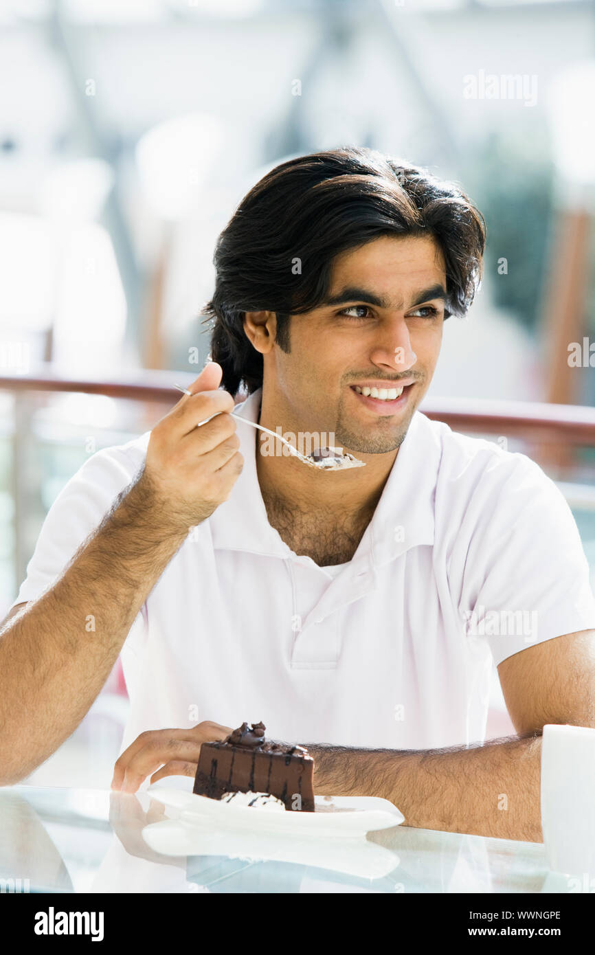 Man at restaurant eating dessert and smiling Stock Photo - Alamy