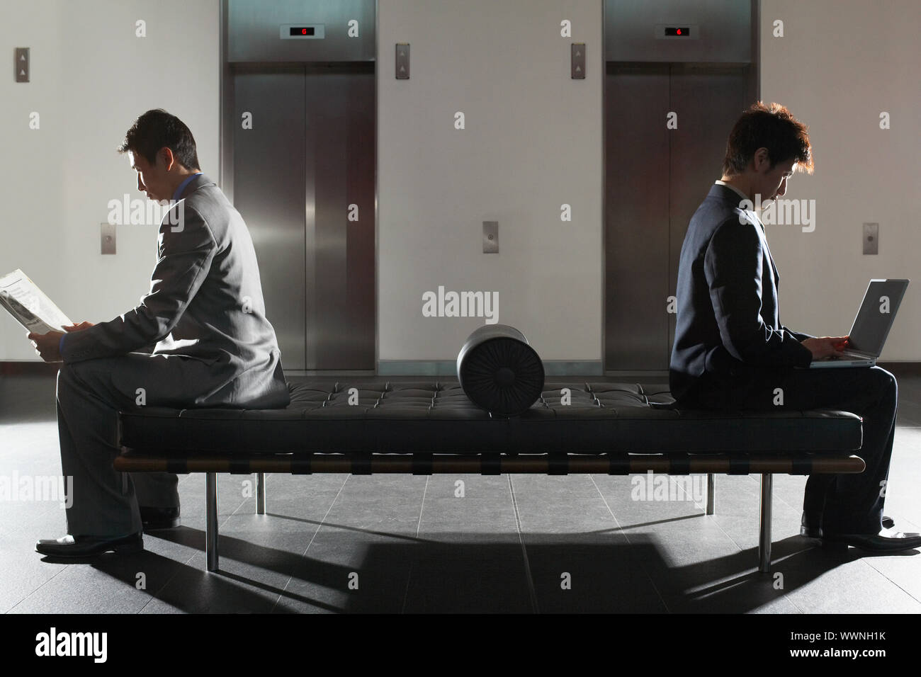 Businessmen Waiting in Lobby Stock Photo - Alamy