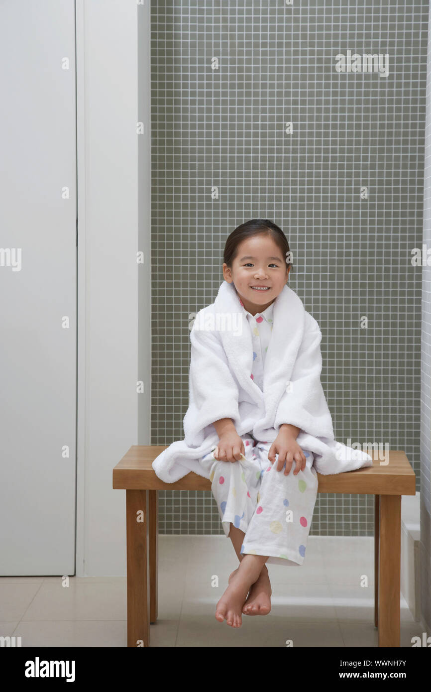 Young Girl Sitting on Bench in Bathroom Stock Photo - Alamy