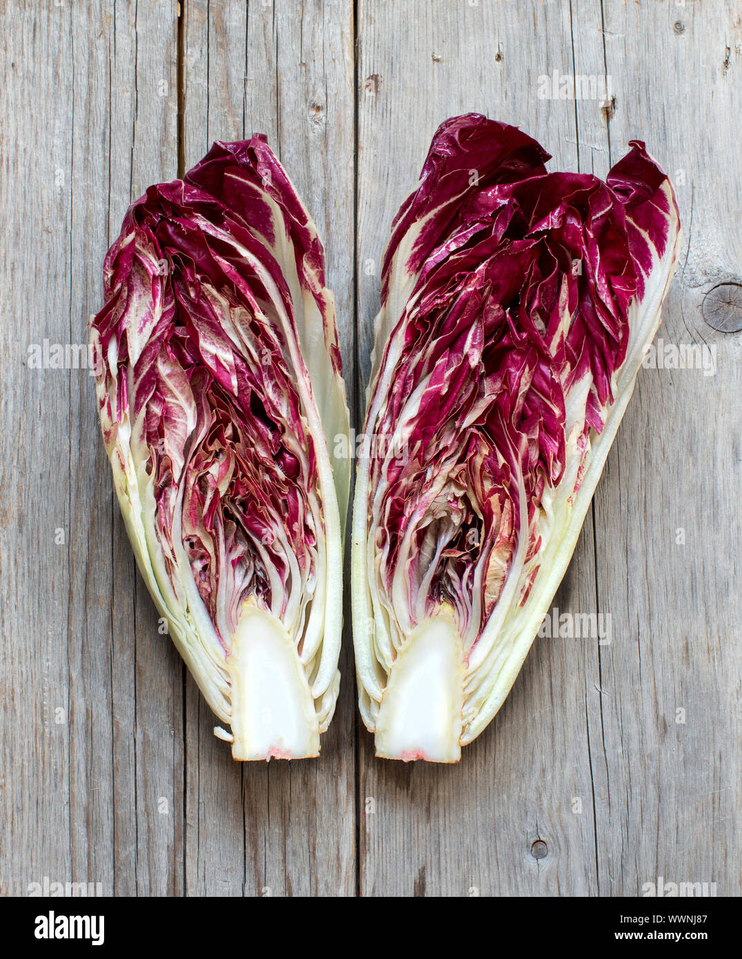Cut in two parts raw red chicory on a wooden table Stock Photo - Alamy