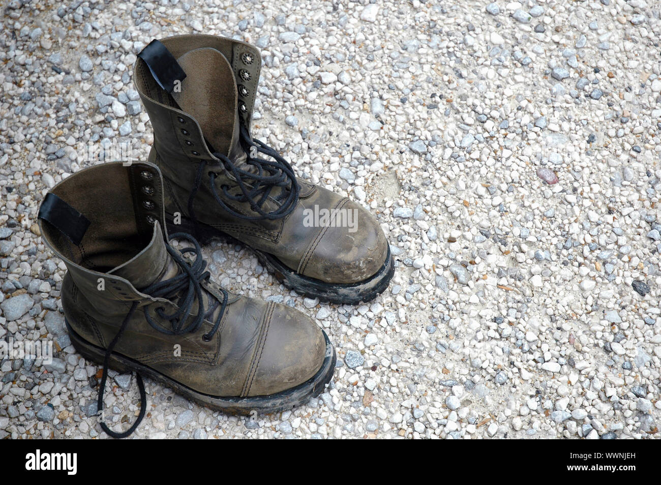 Old worn boots on a rocky floor Stock Photo - Alamy