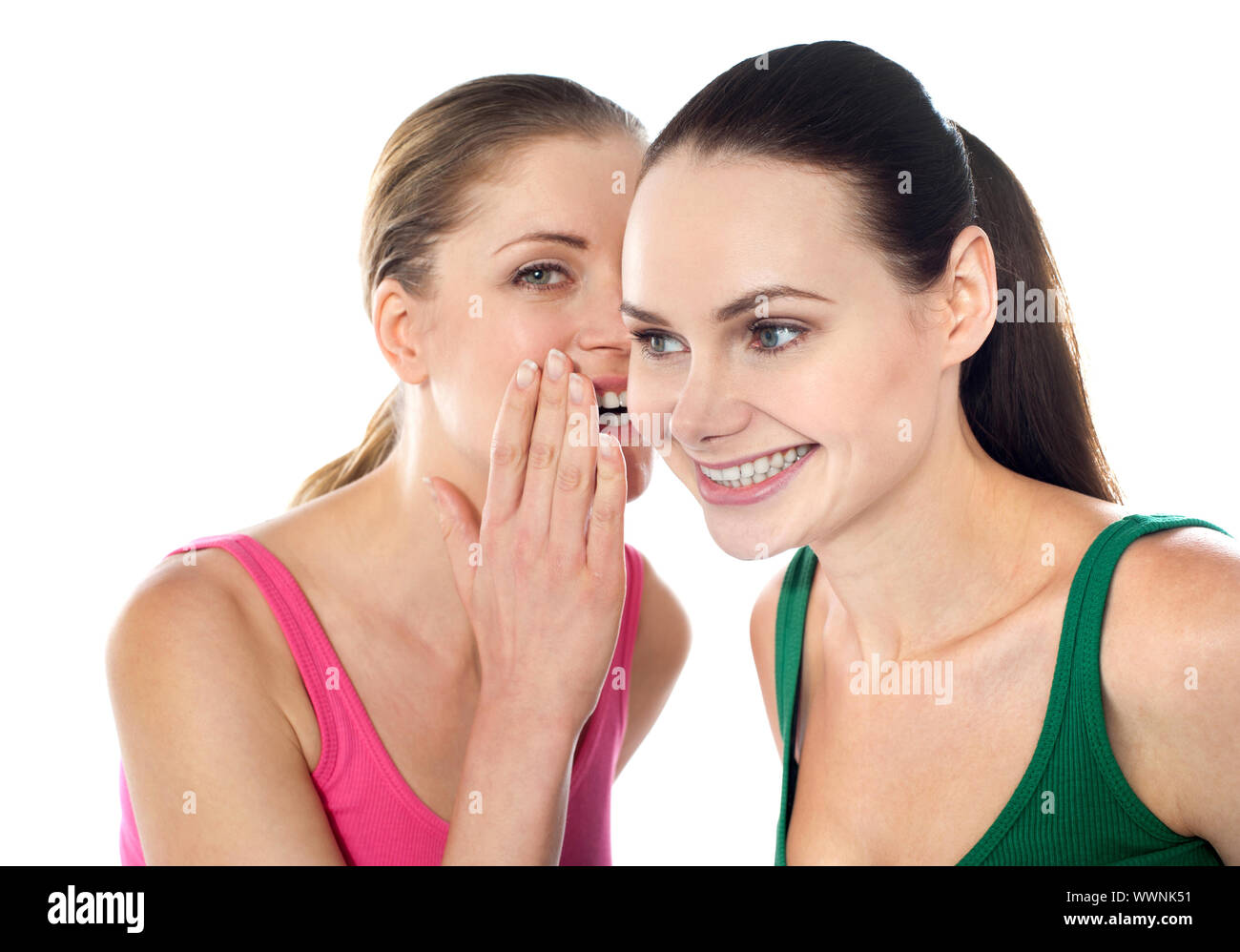 Young beautiful girl whispering secret in her friends ear. Isolated on ...