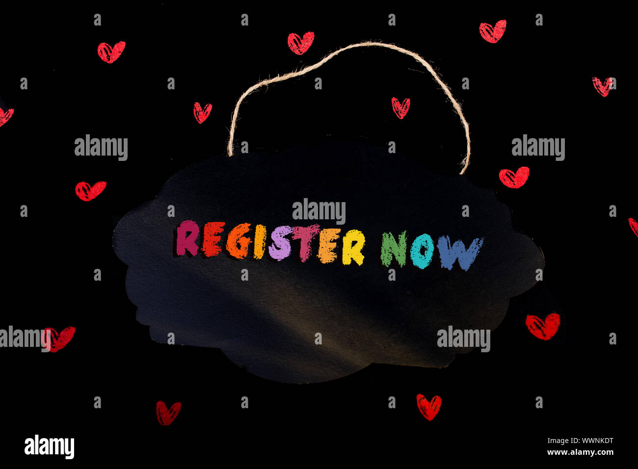 Hand holding sign board with Register now wording on it Stock Photo - Alamy