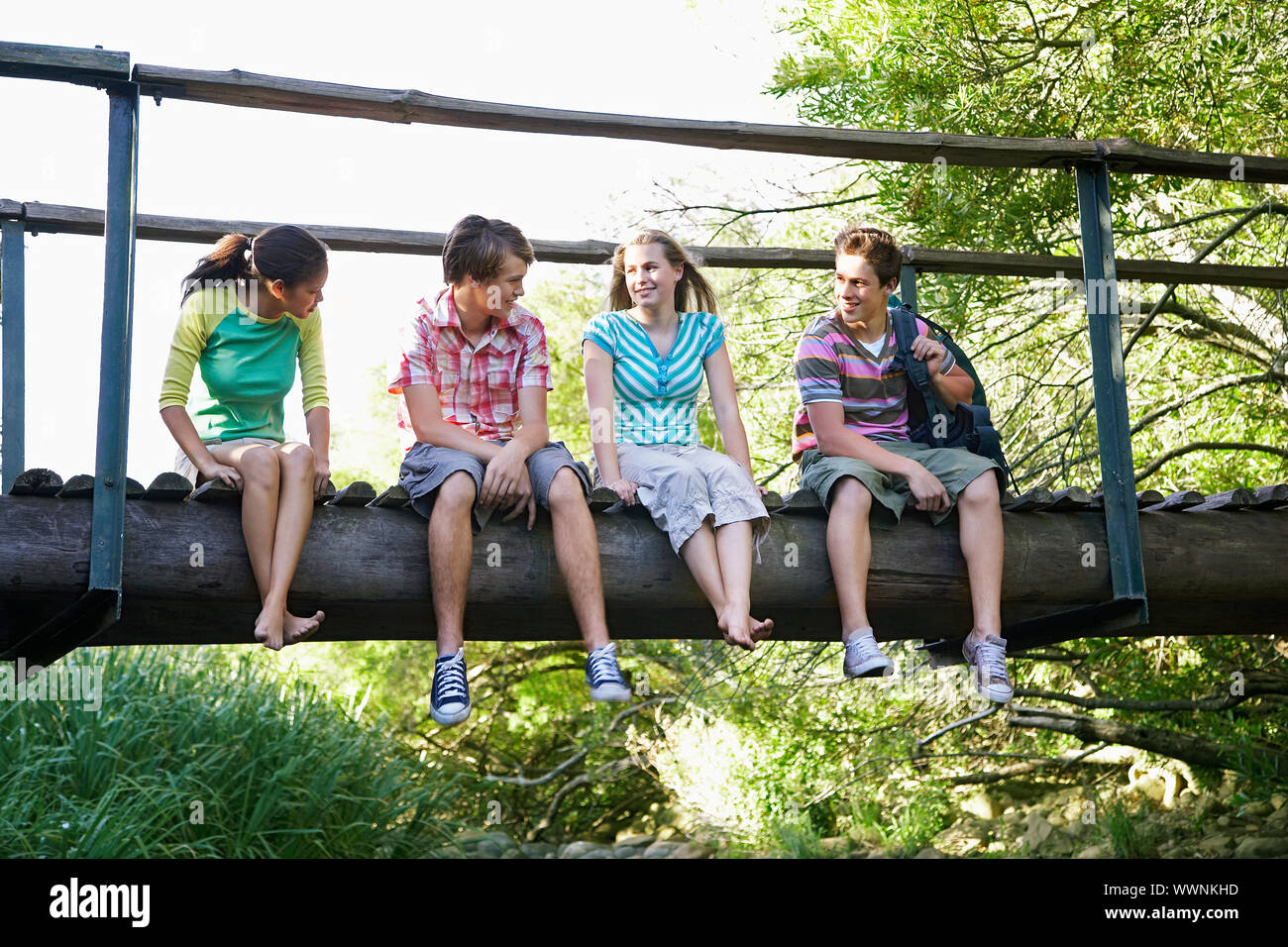 Teens Sitting on Bridge Stock Photo - Alamy