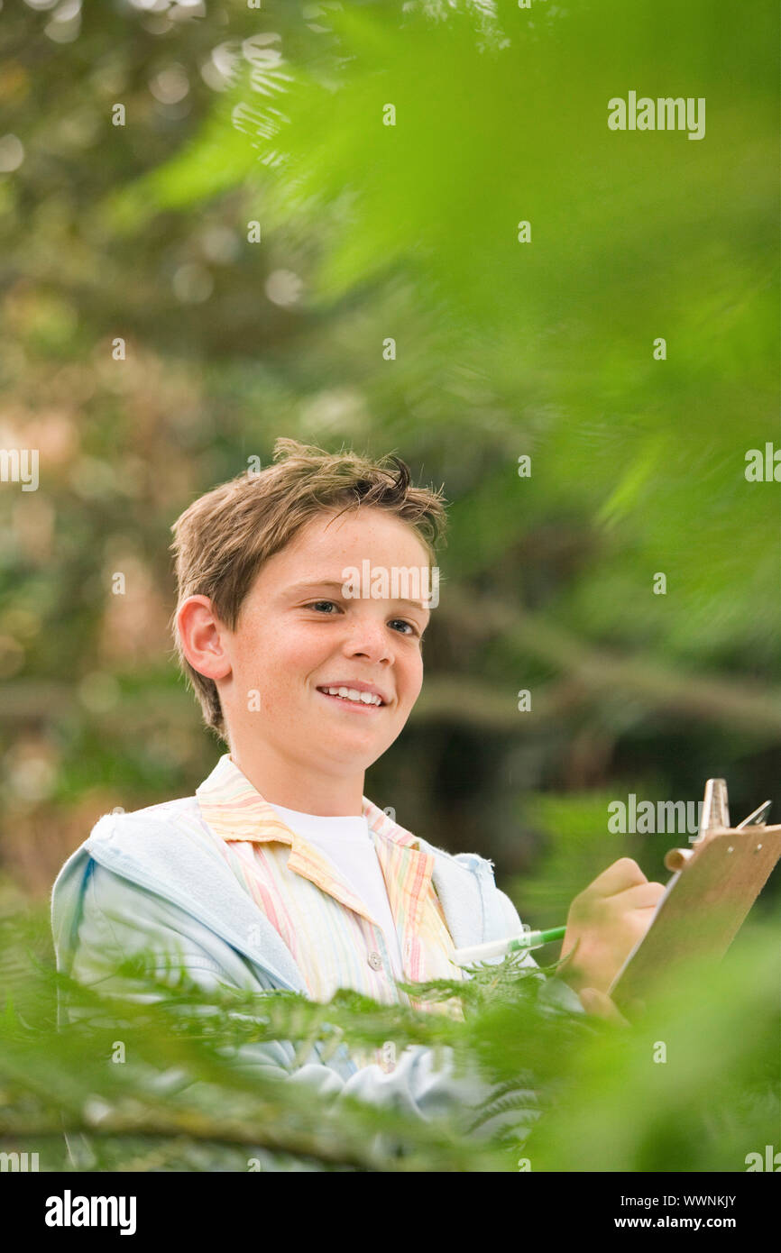 Boy Writing in Forest Stock Photo - Alamy