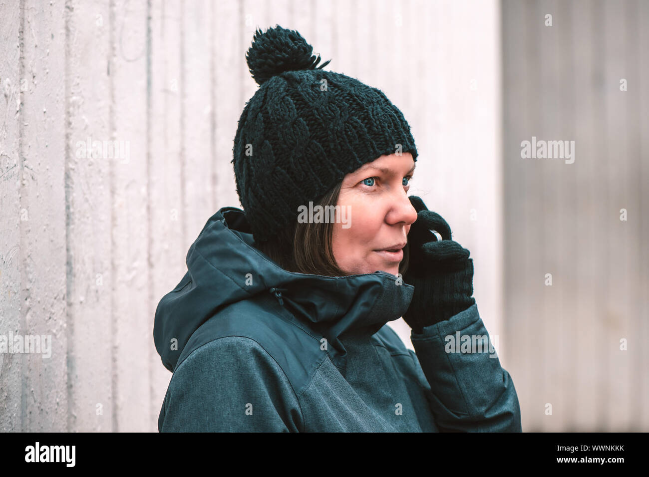 Serious woman talking on mobile phone outdoors on cold winter day Stock ...