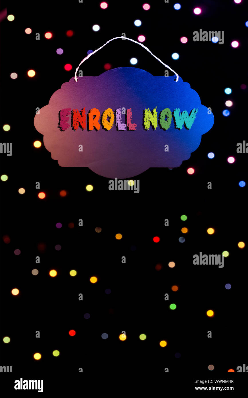 Hand holding sign board with Enroll now wording on it Stock Photo - Alamy