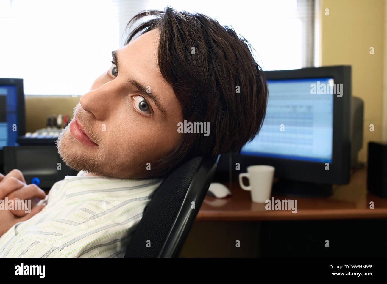 Man on Computer Looking Back Stock Photo - Alamy