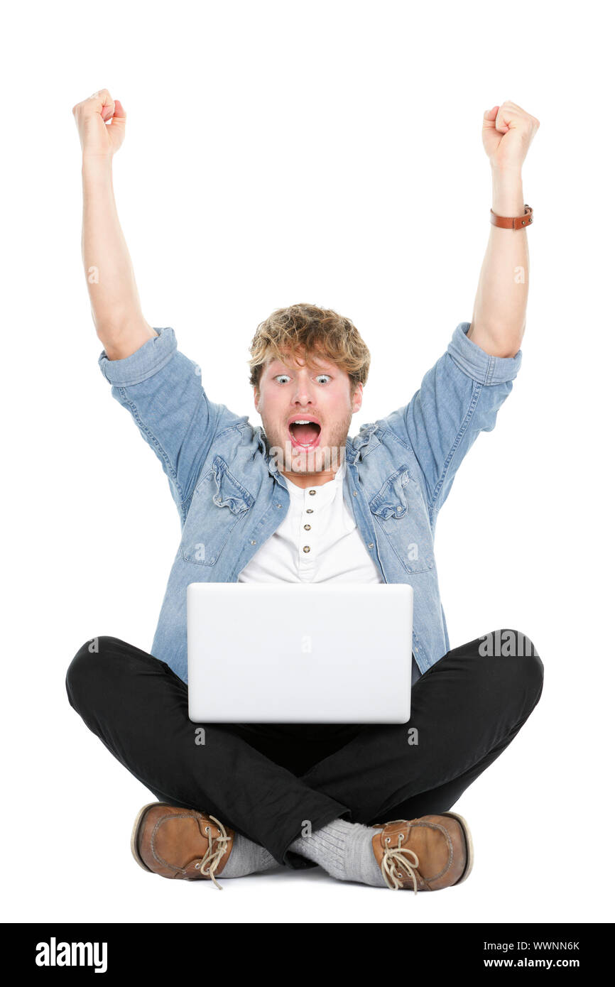 Man cheering with laptop computer and arms raised winning happy. Young ...