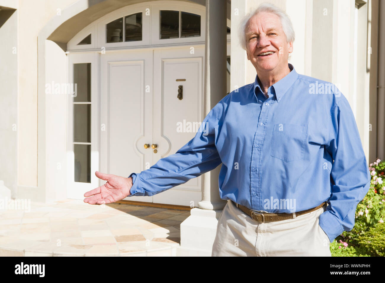 Senior man welcoming visitor to home Stock Photo - Alamy