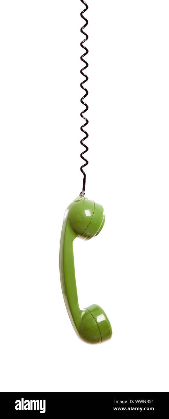 Handset piece from an old phone suspended by the phone cord, isolated ...