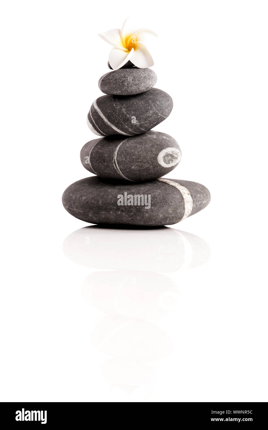 Stones pyramid with a plumeria flower, isolated on white background ...