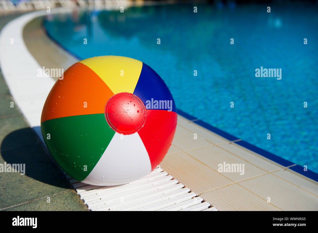 Beach ball laying near the outdoor swimming pool Stock Photo - Alamy
