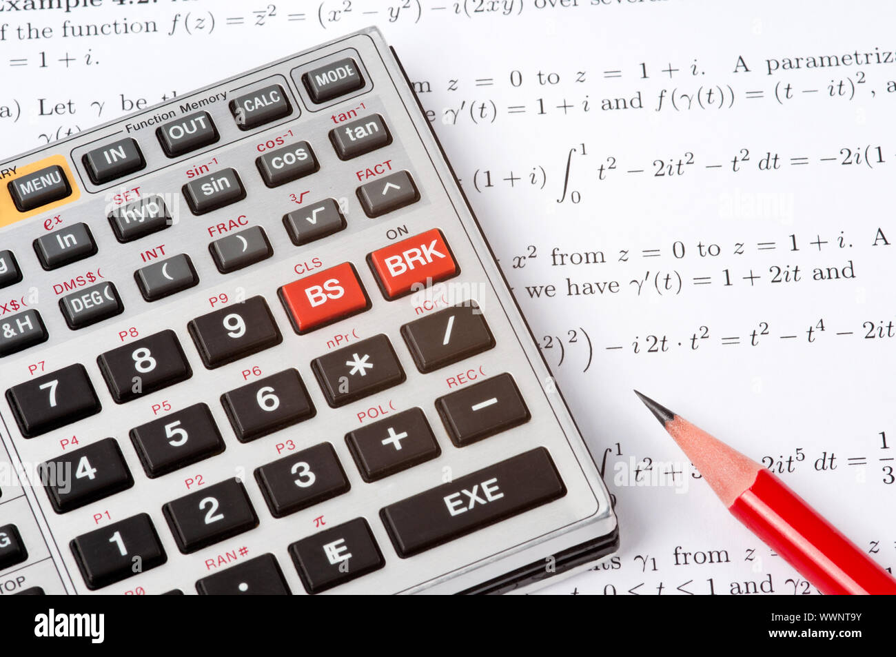 Scientific calculator and a red pencil on top of a sheet of paper with ...