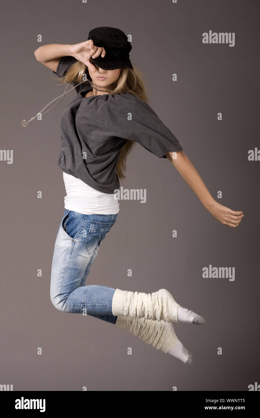 Young women jumping during her dance on grey background Stock Photo - Alamy