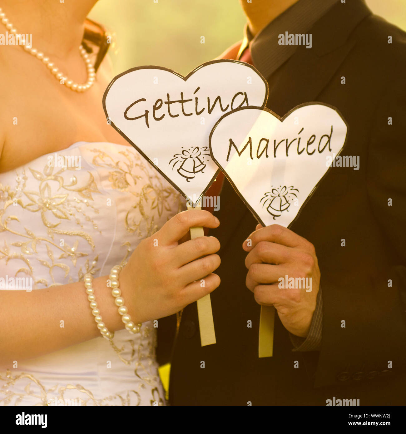 Outdoor Bride and Groom holding getting married sign Stock Photo - Alamy