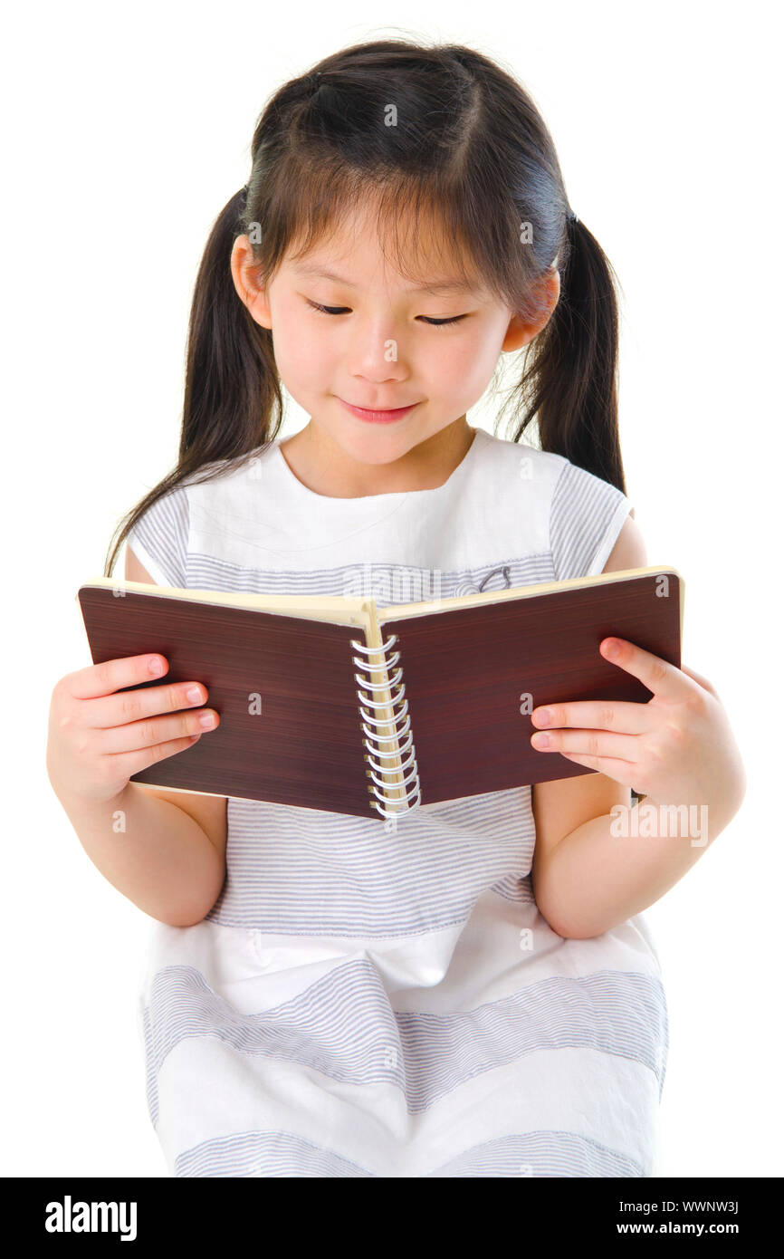 Little Asian girl reading on white background Stock Photo - Alamy