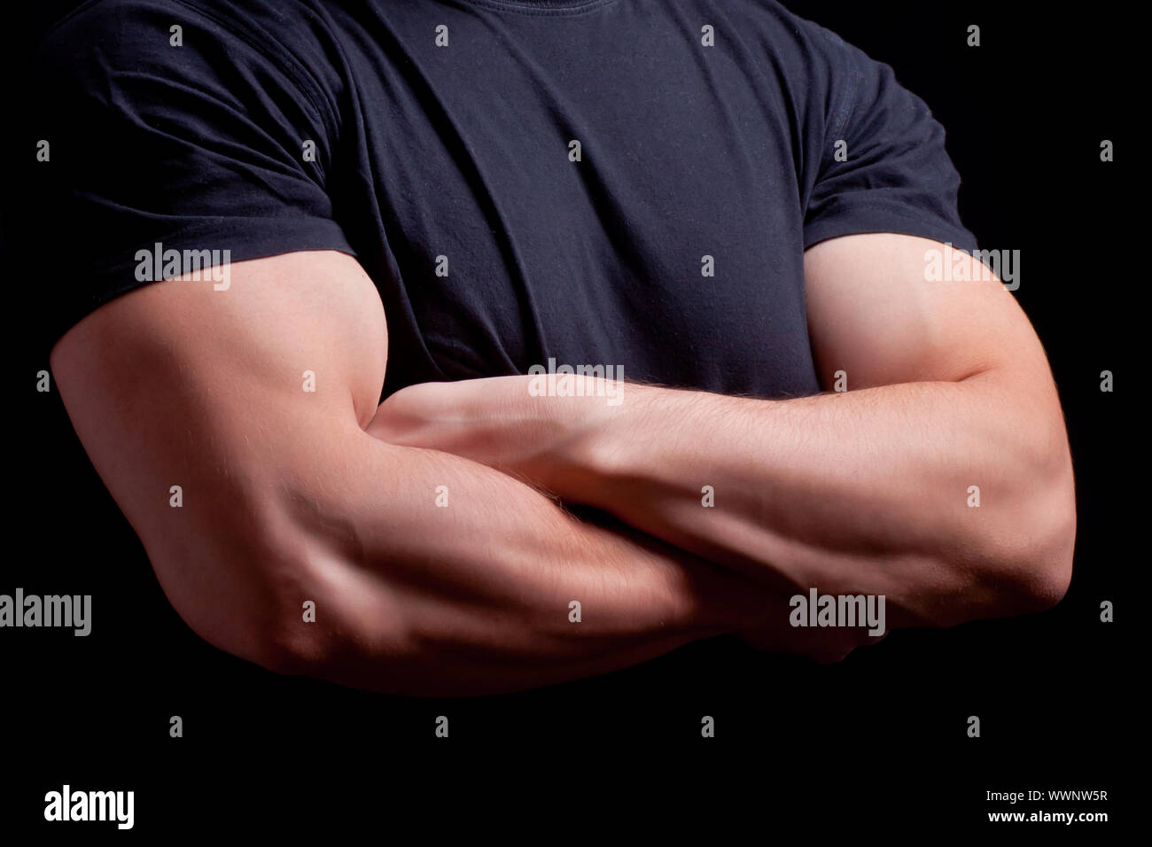 Male security guard with strong arms crossed in a dark background Stock ...