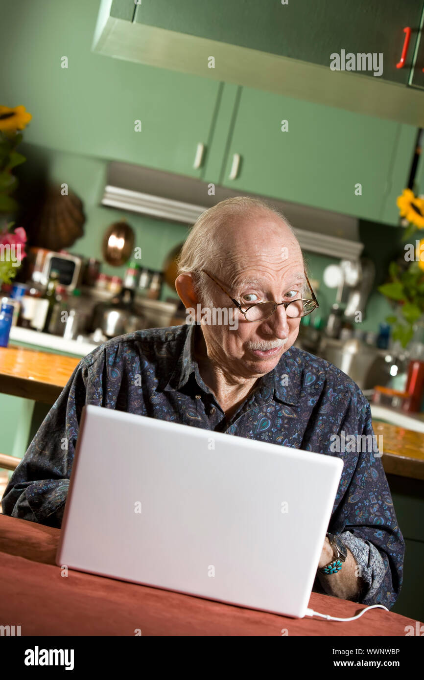 Senior in Dining Room with a Laptop Computer Stock Photo - Alamy