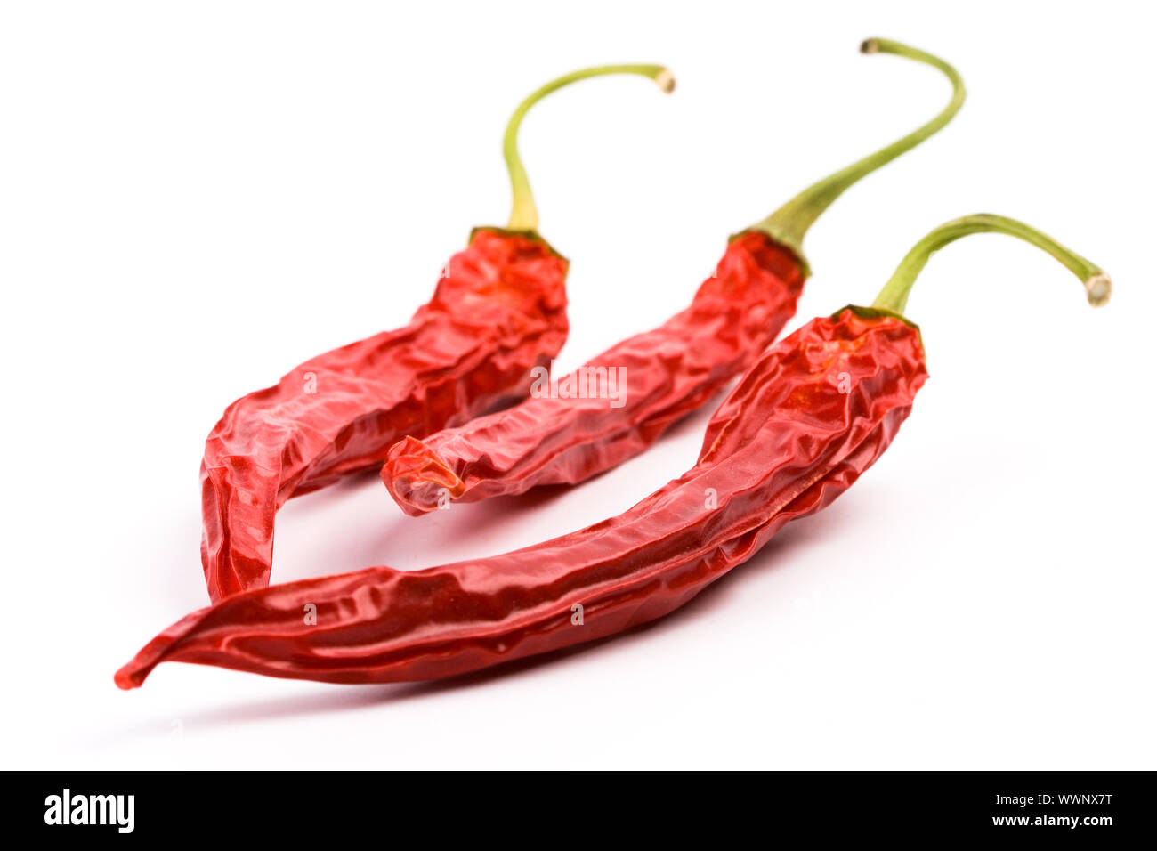 three dry red chilly peppers on white background Stock Photo - Alamy
