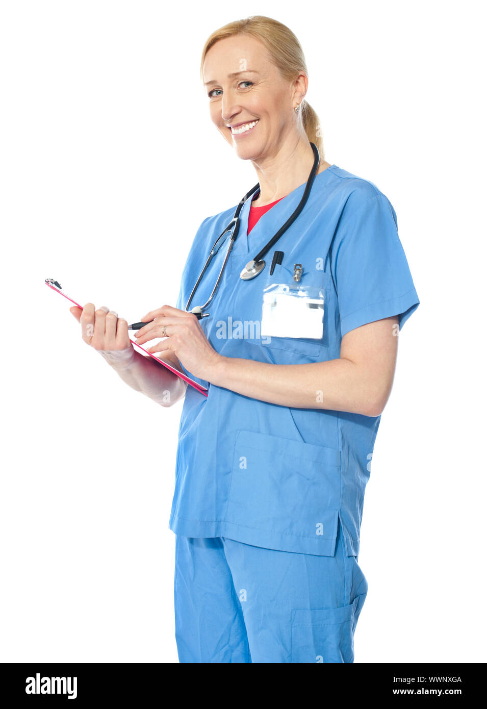 Confident senior doctor writing report and smiling at camera Stock ...
