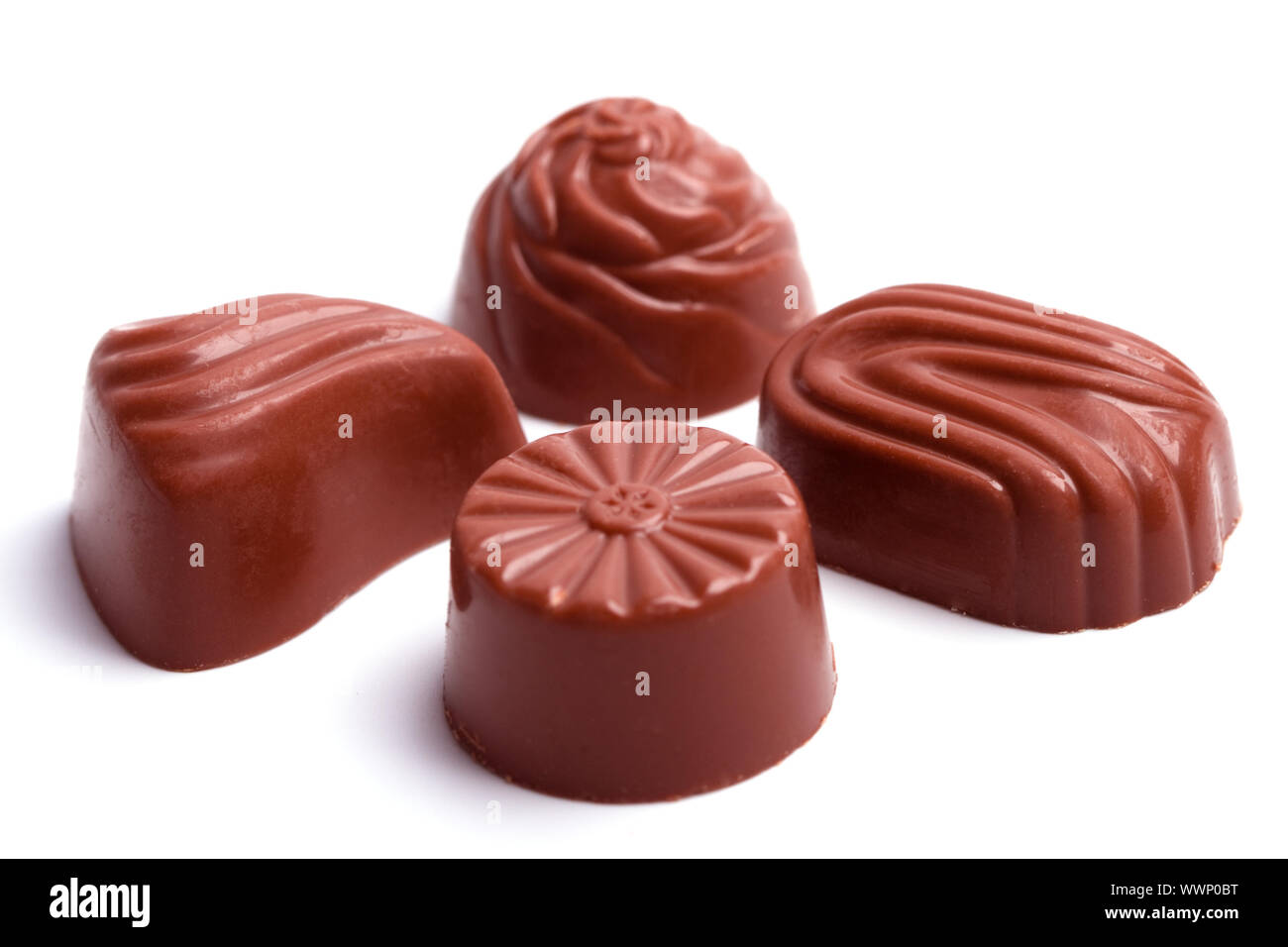 four chocolate sweets on a white background Stock Photo - Alamy