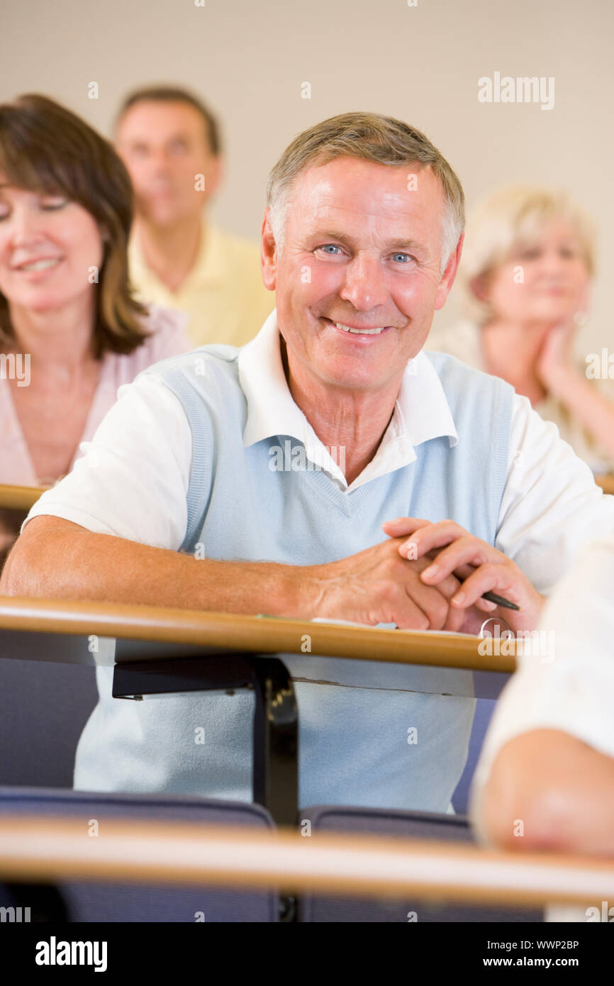 Man sitting in adult classroom with students in background (selective ...