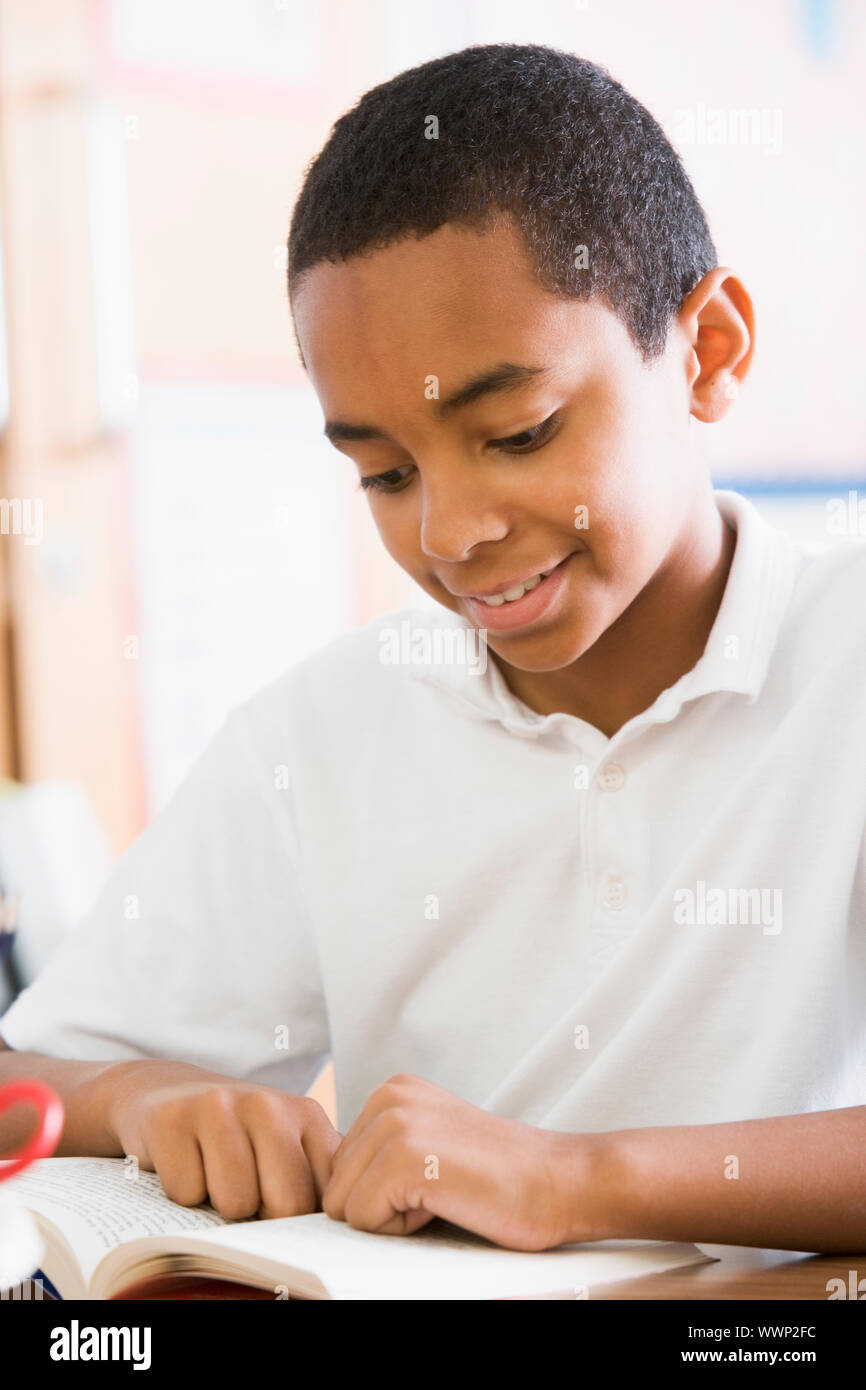 Student in class reading book Stock Photo - Alamy