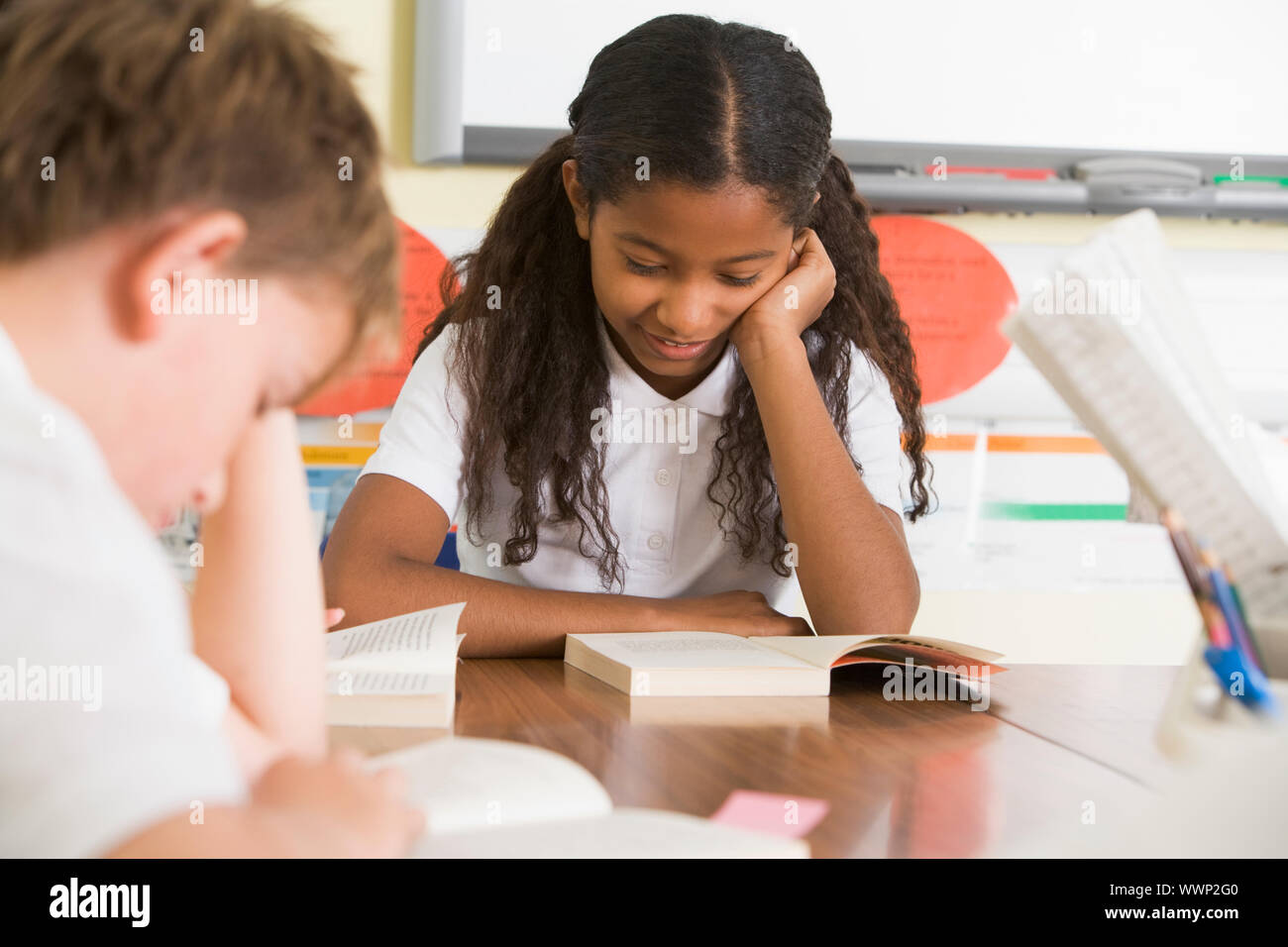 Student in class reading book Stock Photo - Alamy